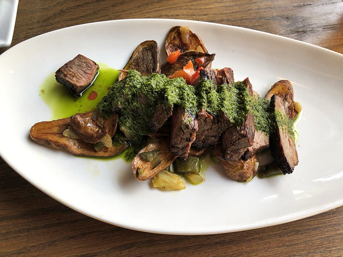 The chimichurri flank steak arrives like a verdant masterpiece &ndash; herbaceous green sauce cascading over perfectly seared beef with artistic precision.