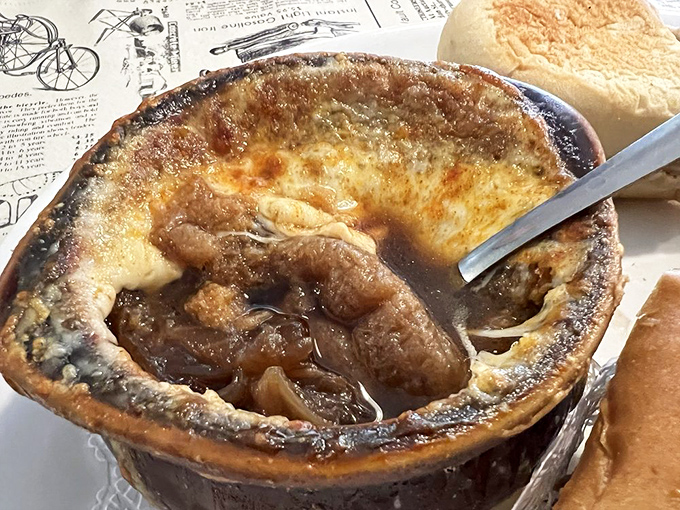 Bubbling cheese forms a magnificent canopy over this classic soup, with caramelized onions waiting below like sweet, savory treasure.