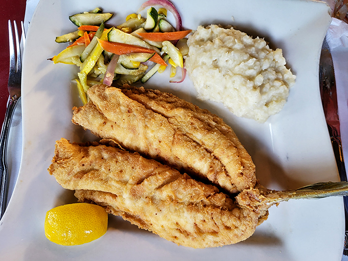 Golden-fried snapper rests beside creamy mashed potatoes and colorful vegetables &ndash; comfort food elevated by the freshness of Florida's waters.