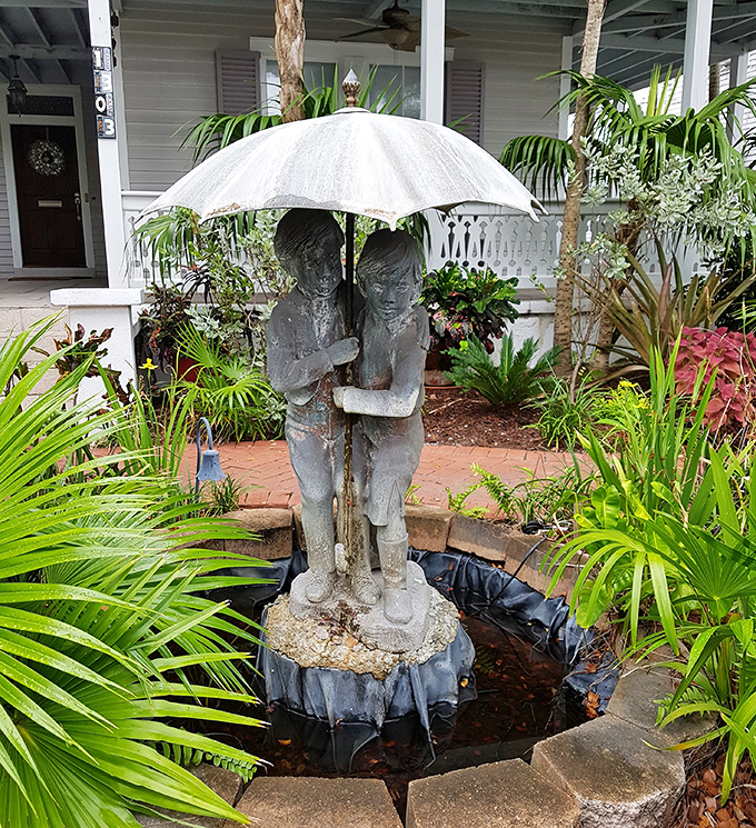 Two children sheltering under an umbrella create a peaceful oasis among the tropical foliage.