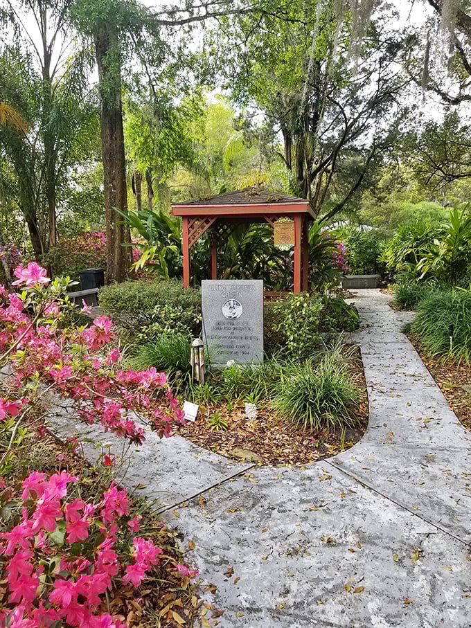 The memorial garden offers a peaceful contrast to the house's spooky reputation, with vibrant azaleas surrounding historic markers.