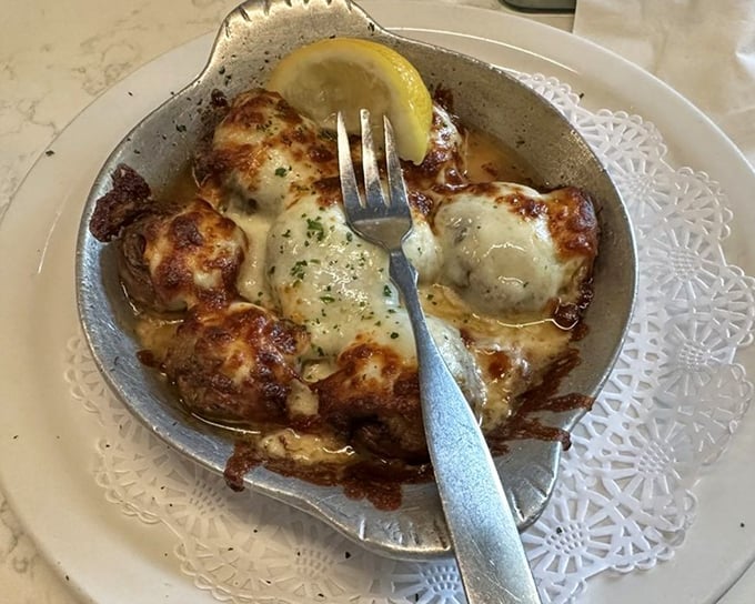 These stuffed mushrooms arrive sizzling hot, their melted cheese topping bubbling over mushroom caps filled with savory goodness &ndash; a starter that sets high expectations.