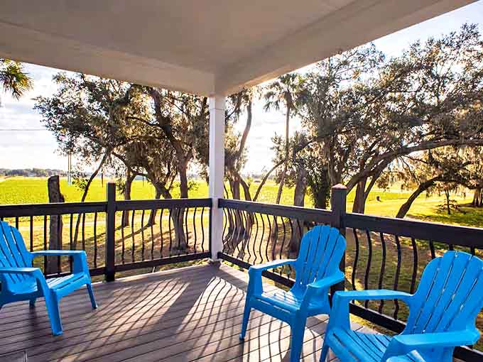 Bright blue Adirondack chairs invite contemplation on the wraparound balcony, where every seat offers front-row views to nature's daily performance.