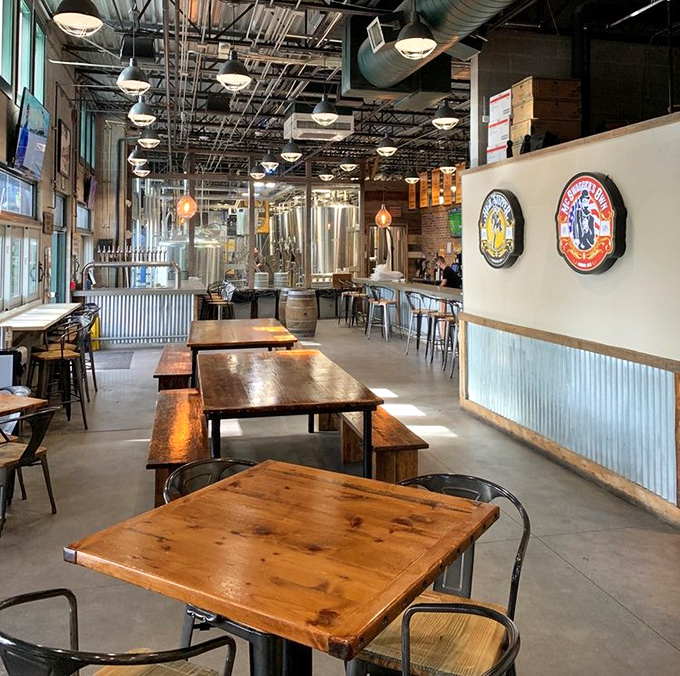 Rustic wooden tables and industrial chairs create a communal dining space where strangers become friends over shared meals.