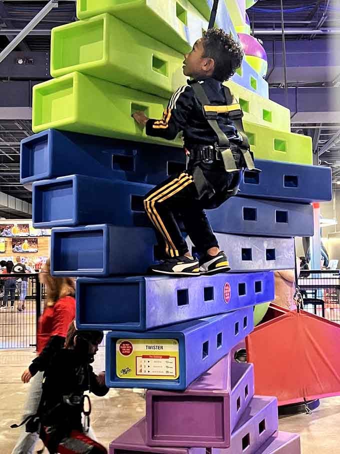 Nothing says "I conquered my fears today" quite like successfully scaling this colorful climbing challenge while everyone watches from below.