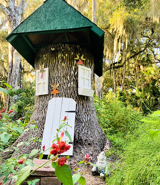 Not your average garden decoration! This tree trunk transformed into a gnome dwelling proves that imagination flourishes alongside the botanical specimens here.