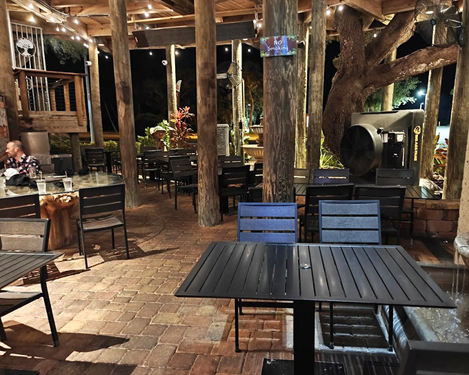 The outdoor dining area incorporates living trees into the experience, with evening lighting creating a magical atmosphere that transforms dinner into an enchanted forest feast.