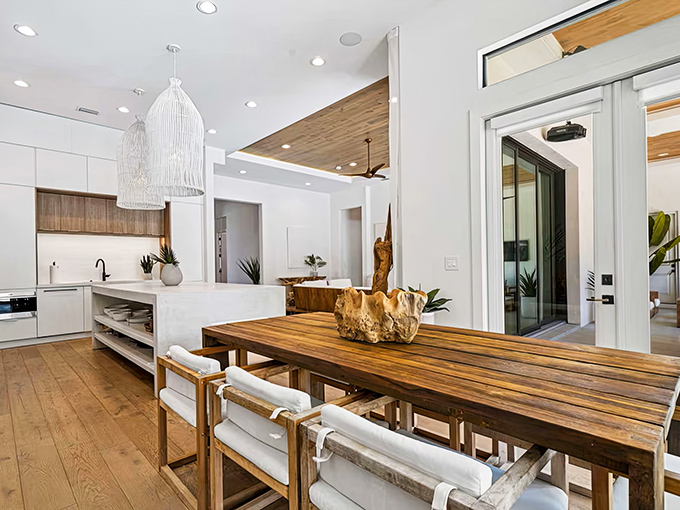Culinary creativity flows in this bright kitchen where wooden accents warm the pristine white space and conversation happens naturally.