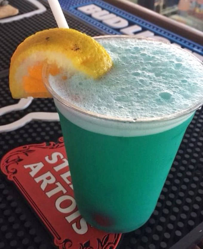 The electric blue "Mermaid Water" cocktail practically glows against the dark bar top &ndash; a drink that tastes like vacation and photographs like a celebrity.