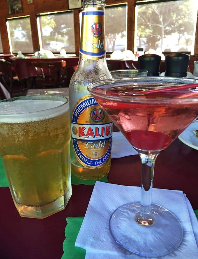 Drinks: A cold Kalik beer stands sentinel beside a ruby-red martini, continuing the tradition of fine libations that once flowed freely during Prohibition's darkest days.