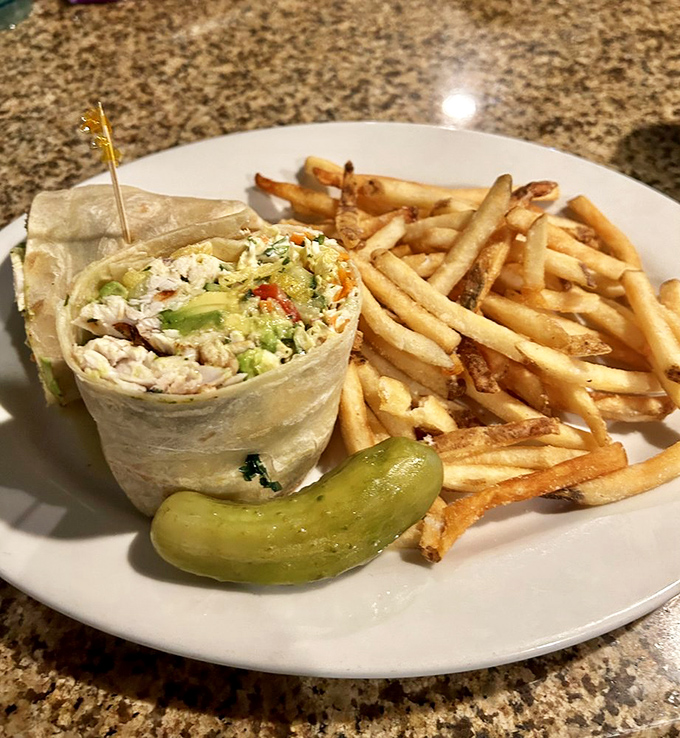 The Blackened Mahi Wrap brings Florida's ocean bounty to land, escorted by golden fries and a pickle for good measure.