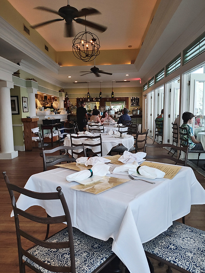 White tablecloths that whisper "special occasion" while ceiling fans lazily remind you that relaxation is non-negotiable here.