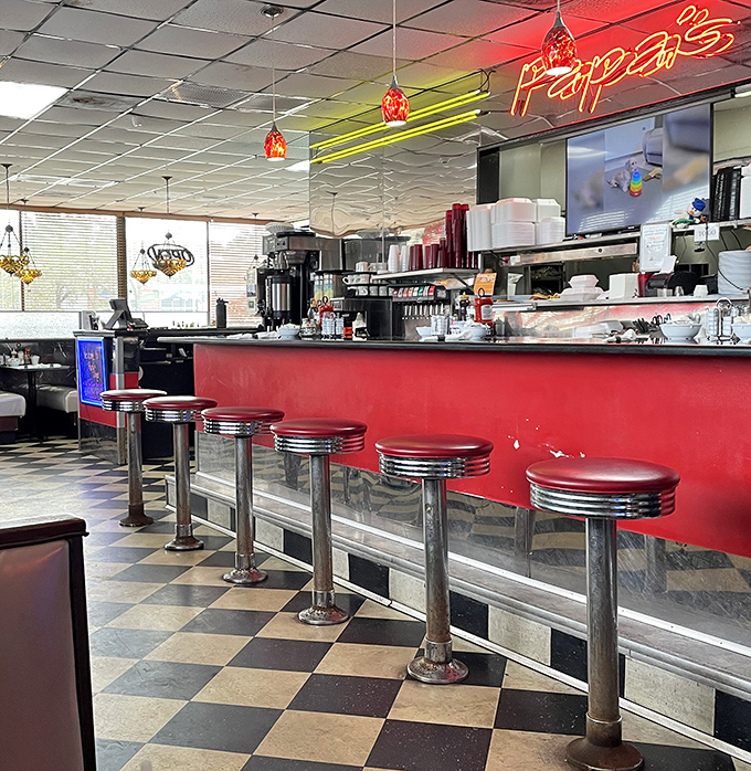 Counter seating with classic red vinyl stools offers front-row views of the kitchen choreography and the best spot for solo diners.