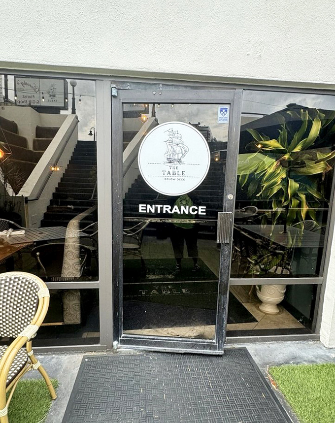 The entrance beckons with understated elegance, a portal to culinary adventures that lie just beyond the threshold and down the stairs.