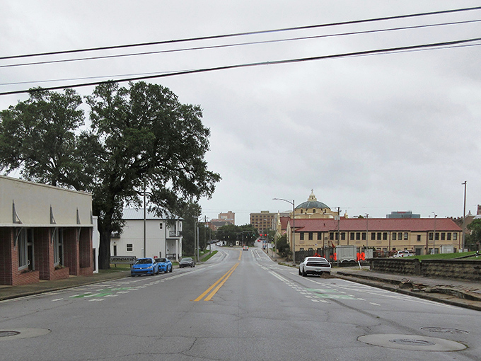 A glimpse of Pensacola's downtown reveals the dome of a historic building peeking through, like a crown jewel against the cloudy sky.