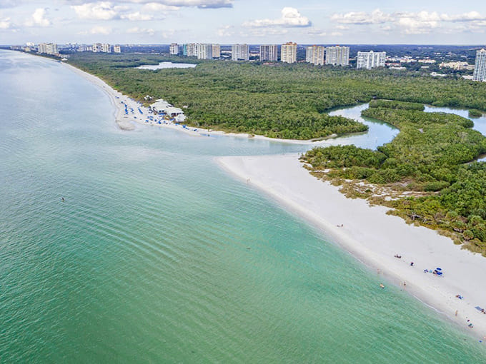The aerial view reveals why Clam Pass Park feels like Florida's best-kept secret, where emerald waters meet pristine shores.