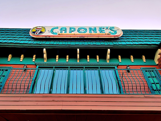 The iconic turquoise and coral exterior of Capone's beckons visitors with its vintage charm and promise of Prohibition-era thrills.