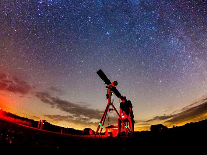 A stargazer's paradise where science meets magic. The Milky Way stretches across the sky while a telescope stands ready to reveal cosmic secrets.