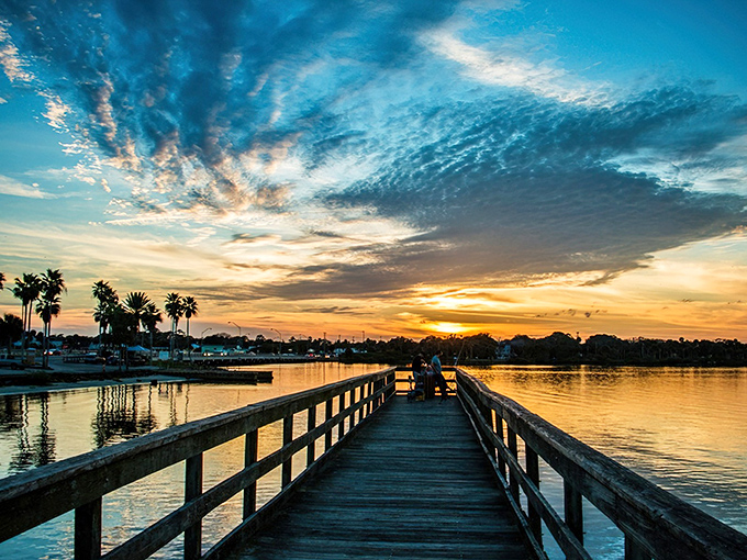 A wooden pier stretches toward infinity as the sun paints the sky in impossible colors – Port Orange's daily masterpiece that never requires tickets or reservations.