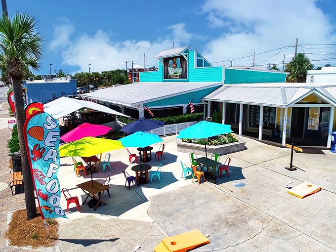 A splash of turquoise against Florida's blue sky, Krazyfish Grille's vibrant patio beckons with a rainbow of umbrellas and laid-back coastal charm.