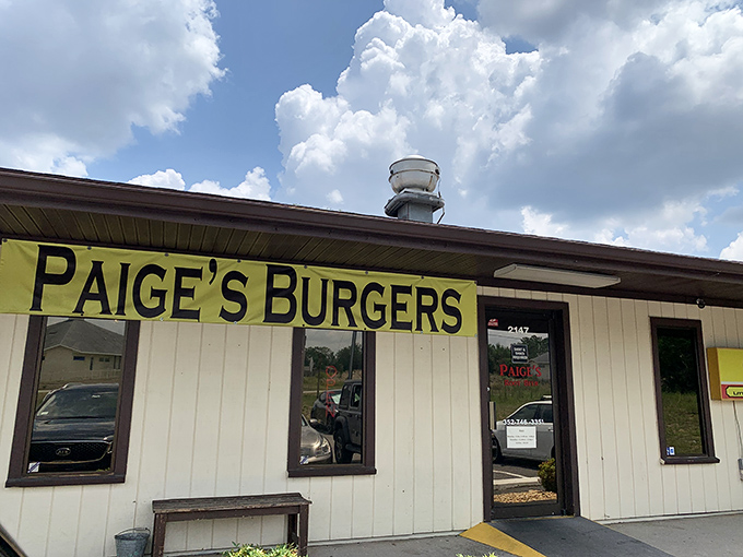 Exterior: The unassuming cream-colored building with its bright yellow "PAIGE'S BURGERS" sign promises straightforward delights without the frills. Classic Americana at its finest.