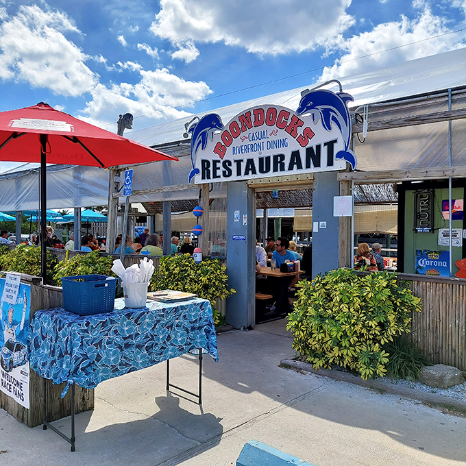 The welcoming entrance to Boondocks Restaurant beckons with its iconic blue dolphin sign, promising casual waterfront dining that delivers far beyond expectations.