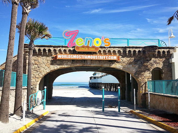 The iconic stone archway entrance to Zeno's beckons beachgoers with its vibrant sign – a sugar-coated portal between ordinary life and sweet escape.