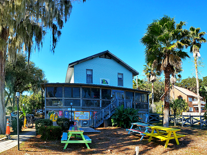The cheerful blue exterior of Three Bananas welcomes visitors with its sunny yellow trim and colorful picnic tables &ndash; Florida casual at its finest.