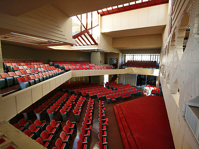 Inside Annie Pfeiffer Chapel, red seats face geometric windows, creating a space where worship and wonder become one.