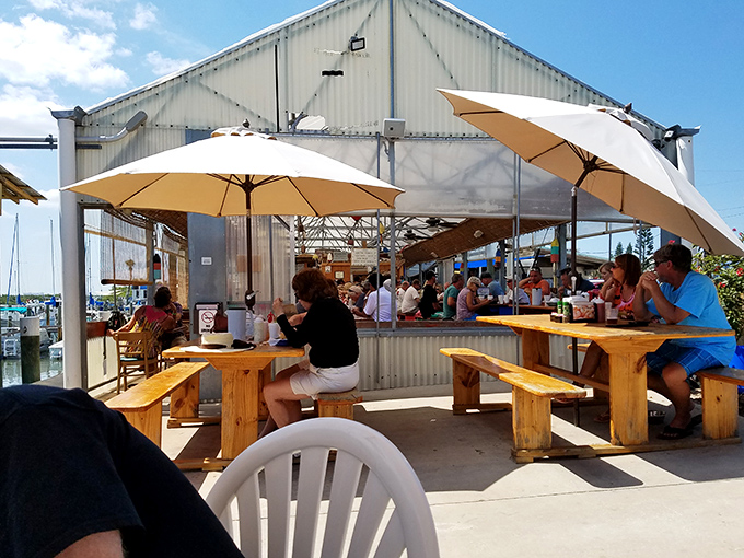 Wooden picnic tables under protective umbrellas invite diners to settle in and enjoy the perfect combination of casual comfort and spectacular views.