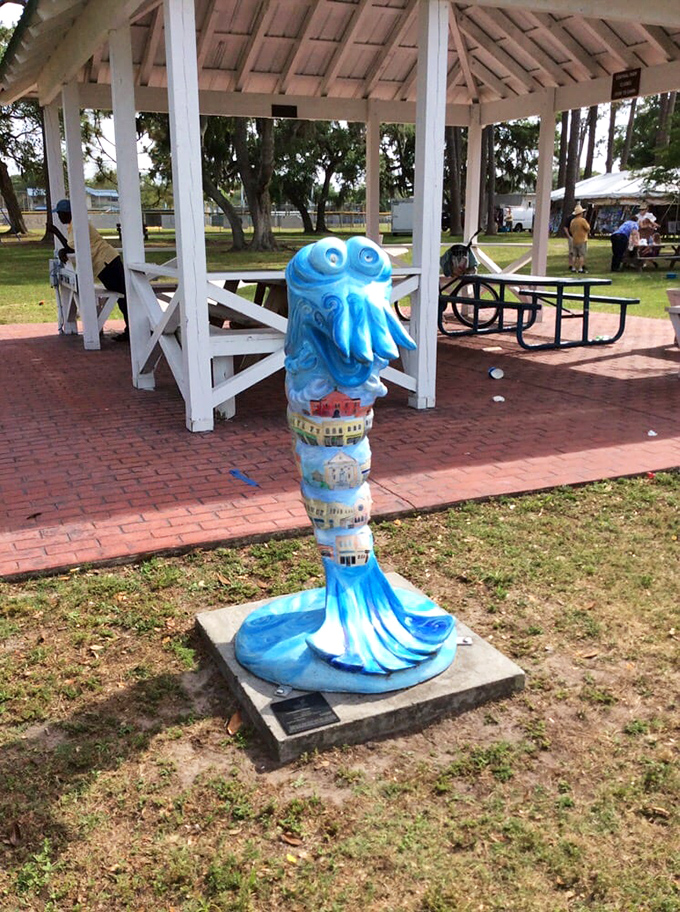 A charming gazebo offers shaded respite, while the blue octopus sculpture adds a whimsical touch of maritime art to the park setting.