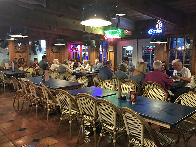 Nautical-themed lighting casts a warm glow over wooden tables where seafood stories and fishing tales are exchanged.