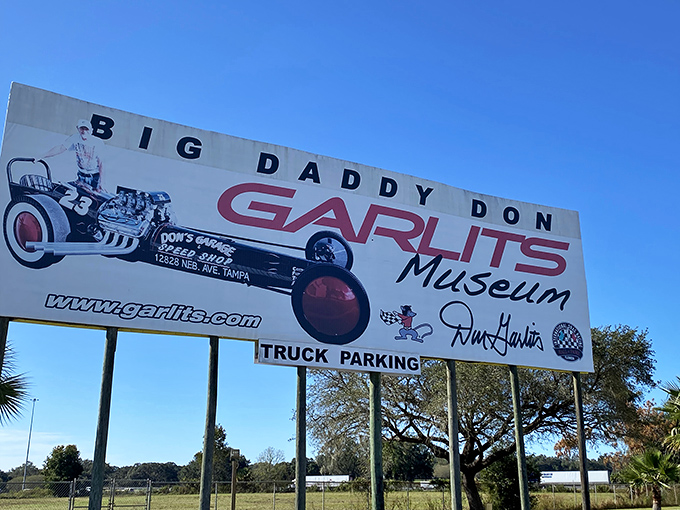 The roadside sign beckons speed enthusiasts with the promise of mechanical marvels and quarter-mile legends inside.