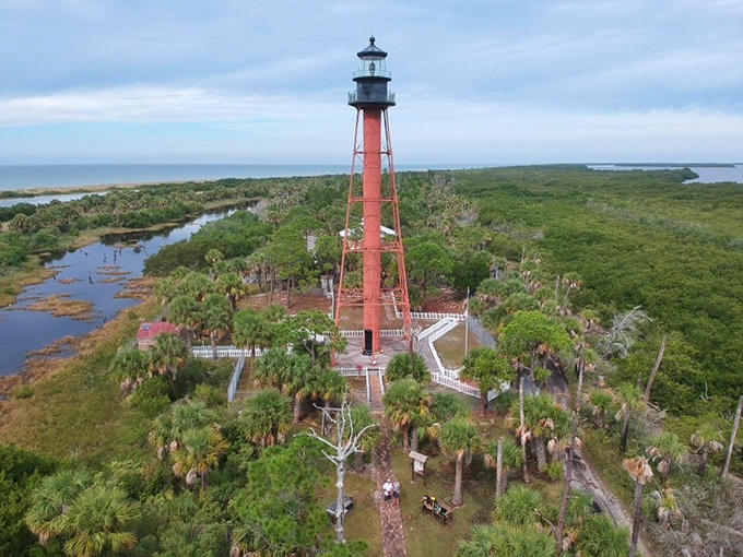 Aerial View: Like a crimson needle in a green cushion, the lighthouse punctuates this untouched island paradise from above.