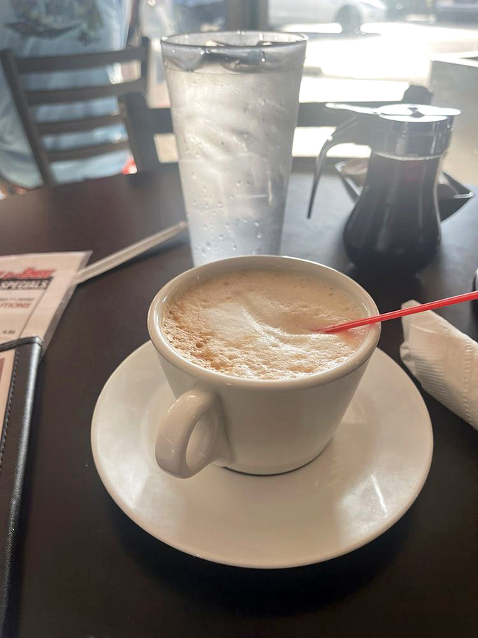 Coffee served in thick white mugs that somehow make it taste better, accompanied by the promise of unlimited refills that keep conversations flowing.