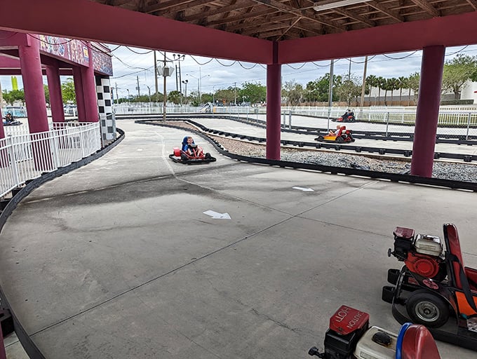 The go-kart track winds like an asphalt ribbon, where family rivalries play out in good-natured races around banked turns.
