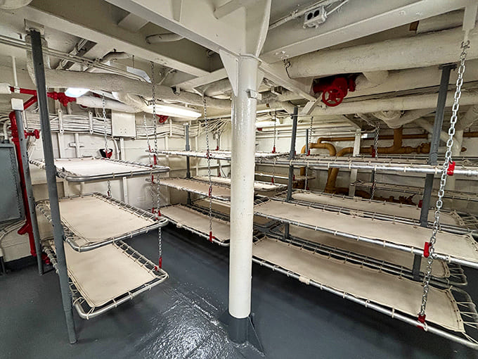 Sleeping quarters show stacked bunks where exhausted sailors grabbed rest between watches, with zero personal space to spare.