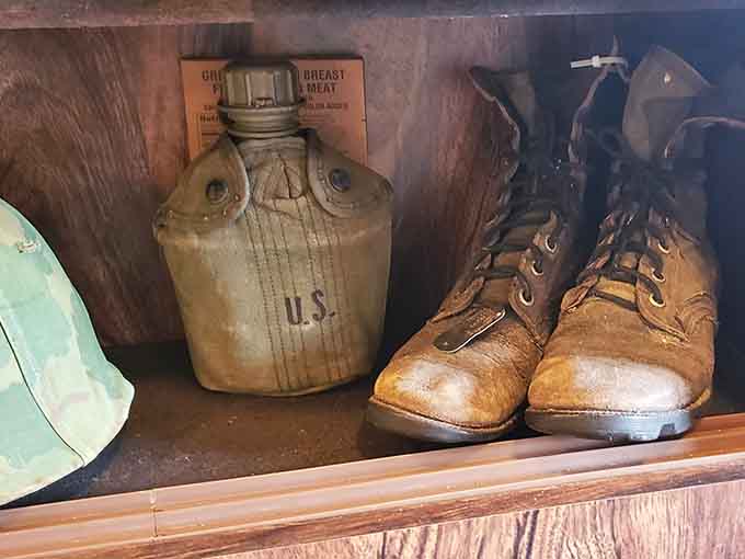 These worn boots and canteen carried someone through unimaginable challenges, each scuff mark telling its own silent story.