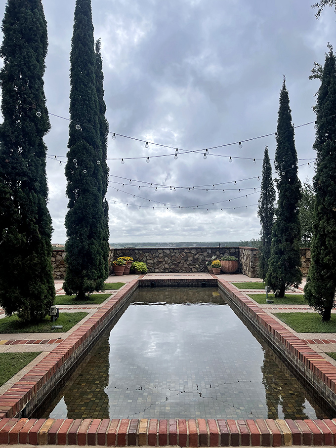 The reflecting pool, surrounded by cypress trees, offers a moment of tranquility that makes you forget you're just a short drive from Mickey Mouse.