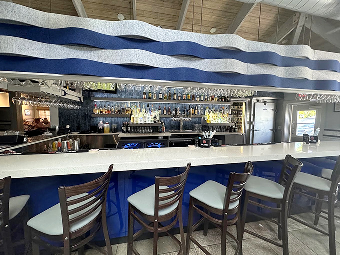 A wave-inspired counter where bottles stand like soldiers ready to transform your ordinary evening into coastal magic.