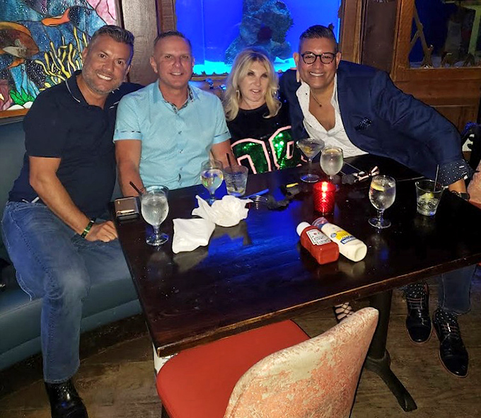 Happy patrons enjoying the unique combination of good company, fine drinks, and the knowledge that mermaids are swimming just feet away.