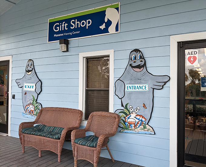 The gift shop entrance features cheerful manatee ambassadors, their cartoon smiles inviting visitors to take home memories and support conservation.
