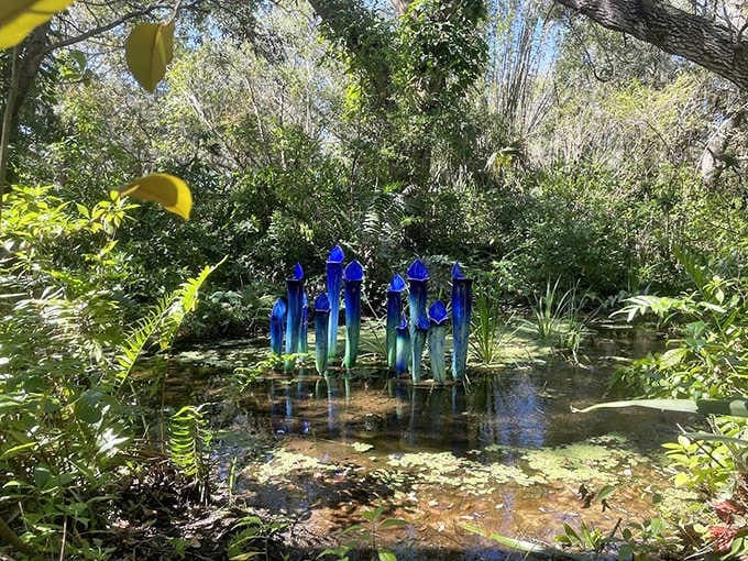 Slender blue sculptures rise from the water like a school of mystical sea creatures frozen in an elegant underwater dance.