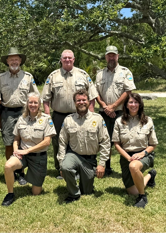 The guardians of paradise pose beneath ancient oaks. These rangers protect the delicate balance between accessibility and preservation.