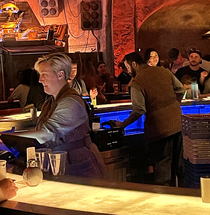 These aren't mere servers but character actors maintaining the illusion that you've truly left Earth behind for a distant outpost.