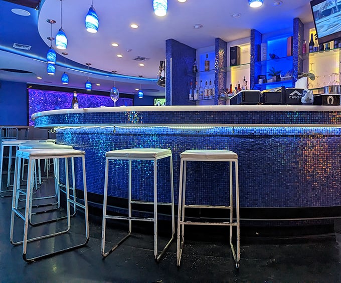 The blue mosaic bar glows like bioluminescent waters, making even a Tuesday night feel like a special occasion worth celebrating.