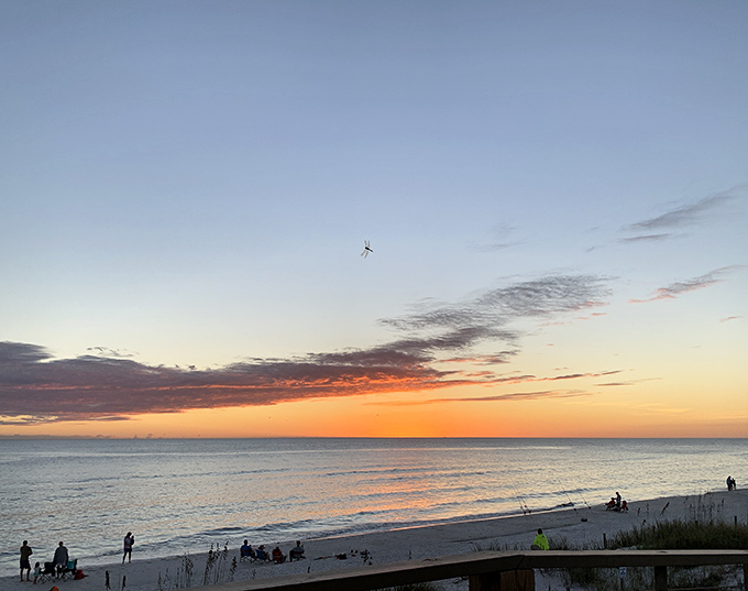 Visitors gather along the shore, united in the shared experience of witnessing day's magnificent transition to night.