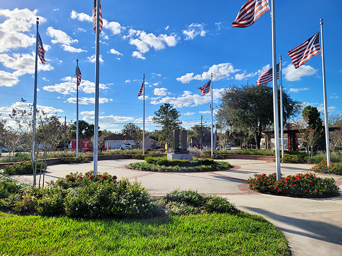 American flags circle this veterans memorial, creating a space where patriotism and peaceful reflection coexist beautifully.