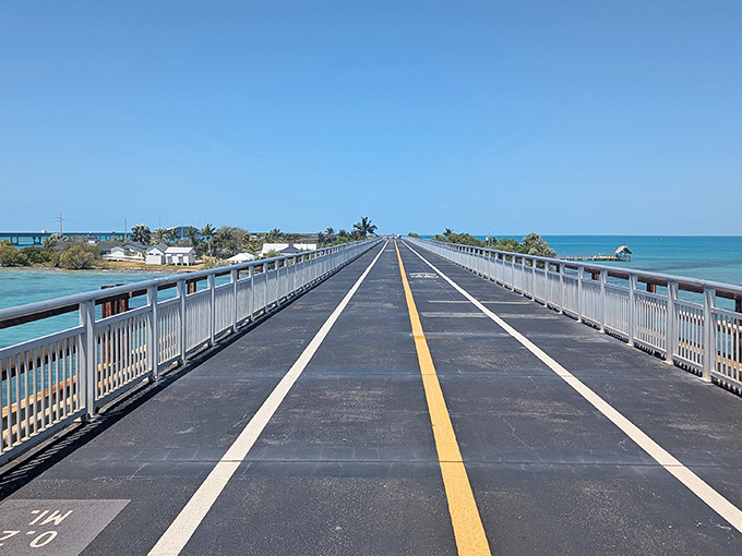 Walking the historic span feels like stepping into a postcard – concrete beneath your feet, endless blue surrounding you in every direction.