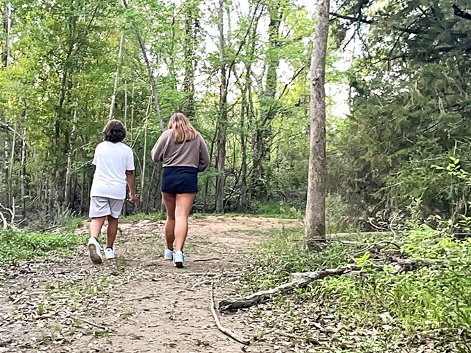 Two adventurers explore the trail, unaware they're walking the same path as countless visitors seeking ghostly encounters.